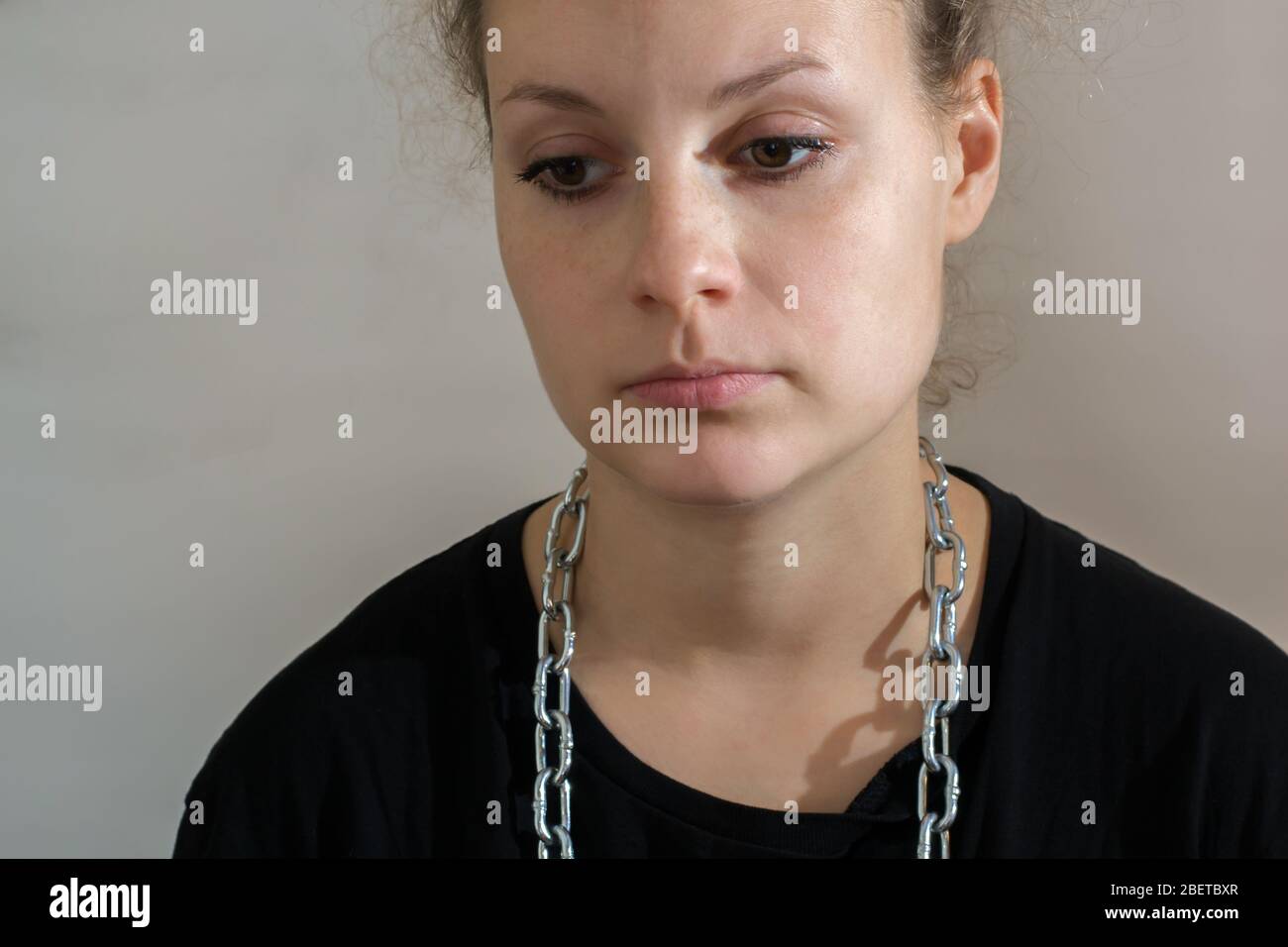 Sad girl in black clothes with a heavy chain around her neck Stock ...