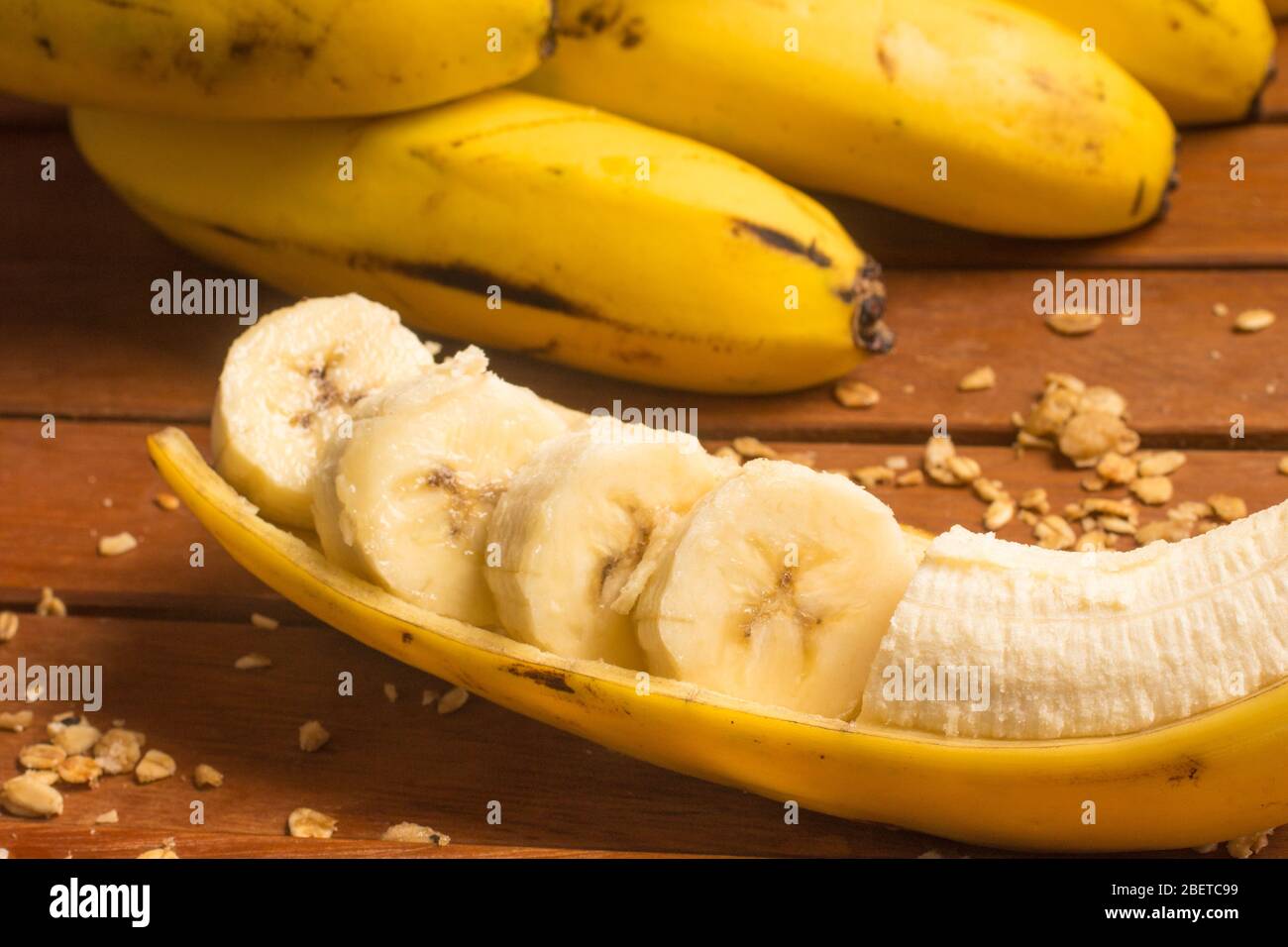 Sliced Banana and granola over a wooden table Stock Photo - Alamy