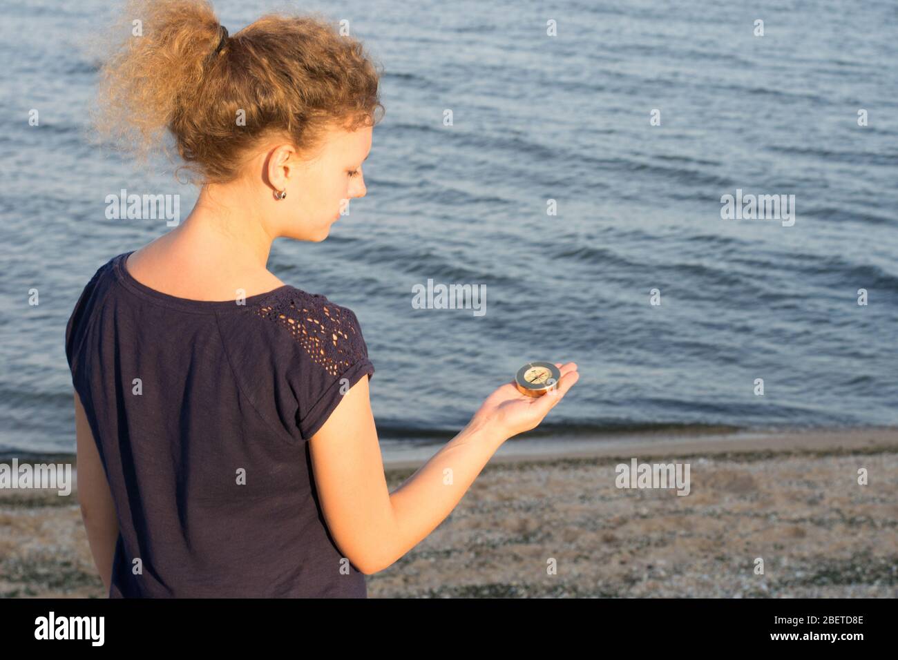 Girl holds a compass indicating the direction of the background of the ...