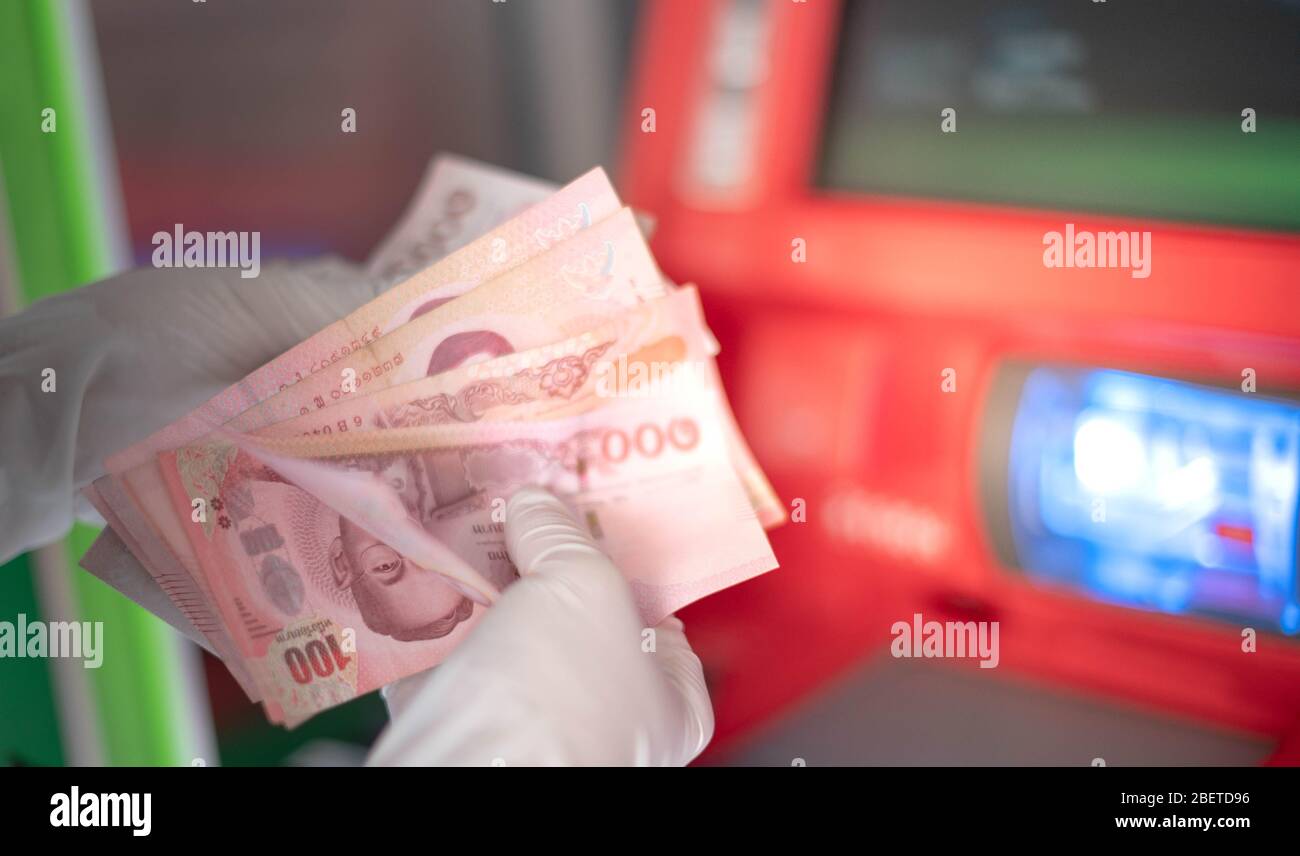 Female hands to holding cash from ATM key in the red cabinet. Finger ...
