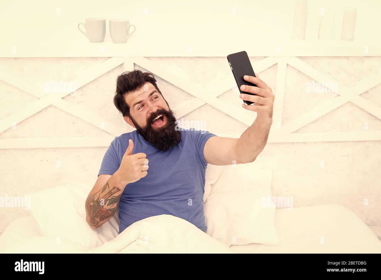 Just thumb up. Happy hipster give thumb up to phone camera. Bearded man ...