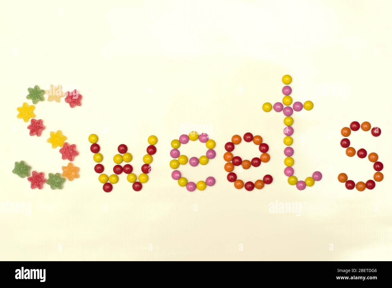 A word Sweets lined with colorful candies on a light background Stock ...