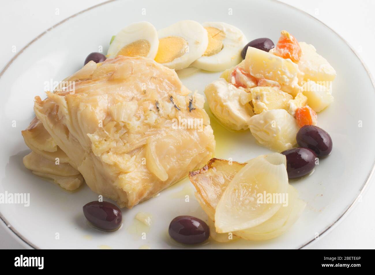 Meal of Boiled Cod Fish with black olives and potatoes Stock Photo - Alamy