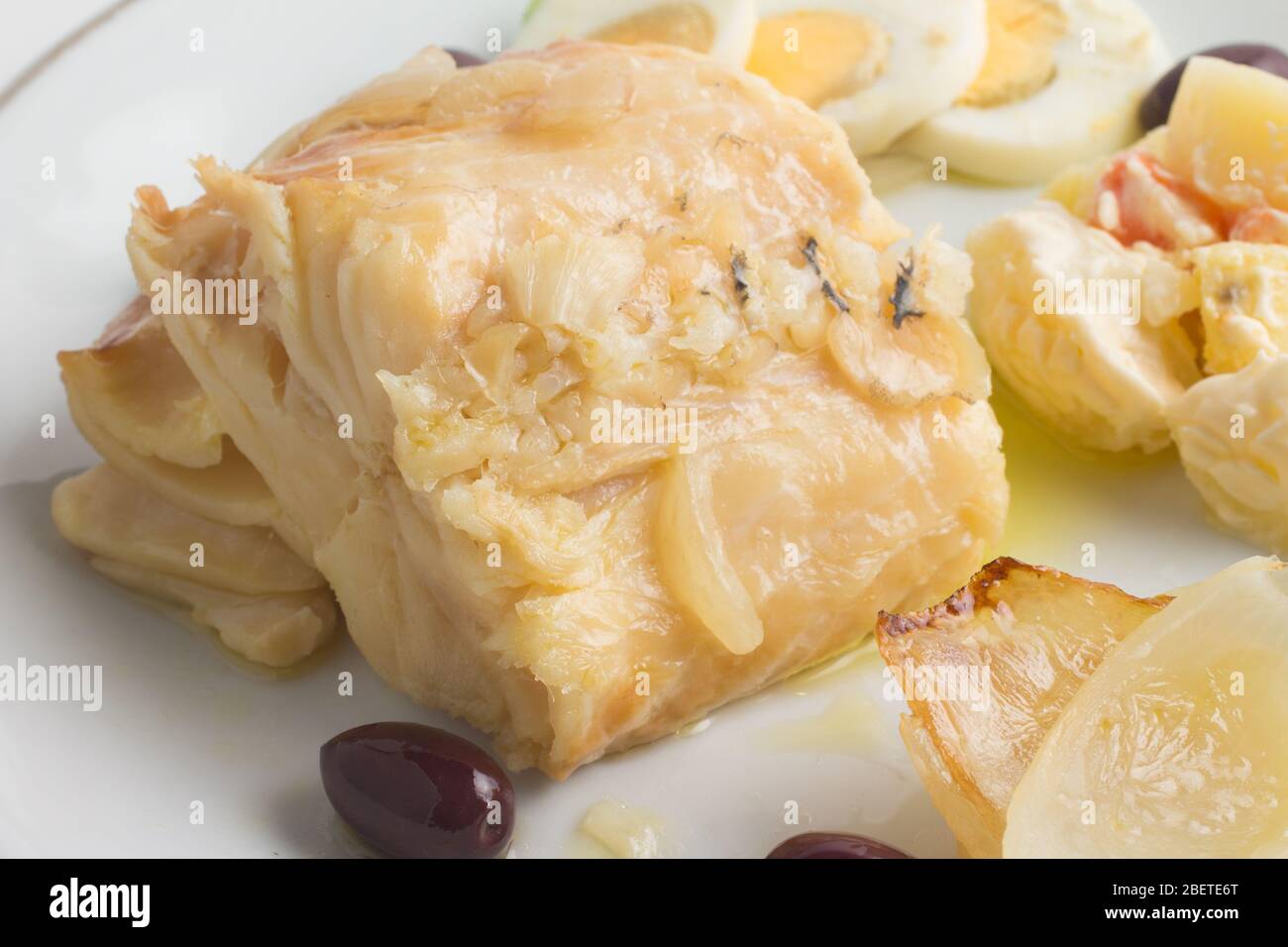 Meal of Boiled Cod Fish with black olives and potatoes Stock Photo - Alamy