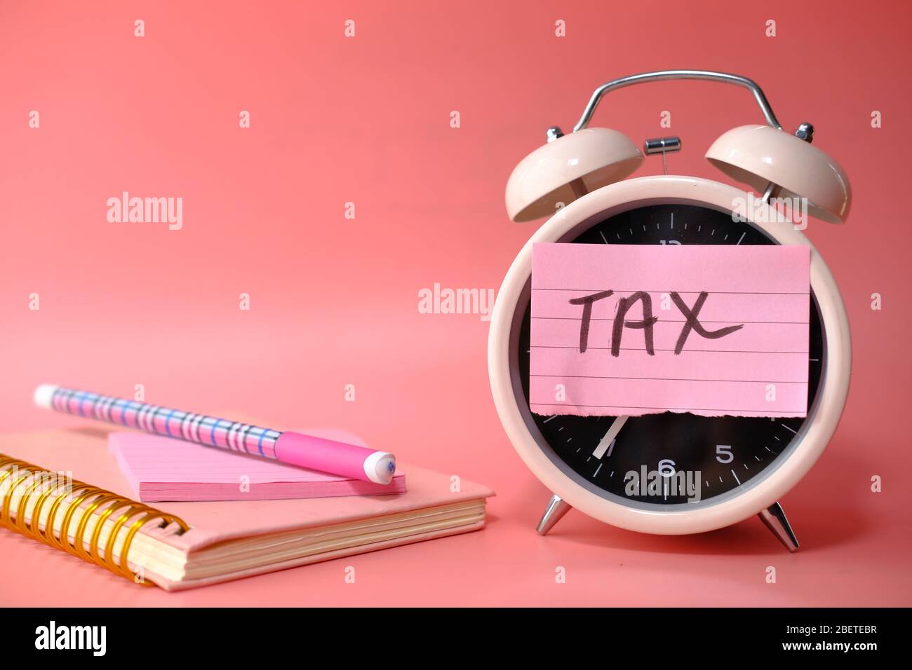 tax time post-it on alarm clock on pink background Stock Photo - Alamy