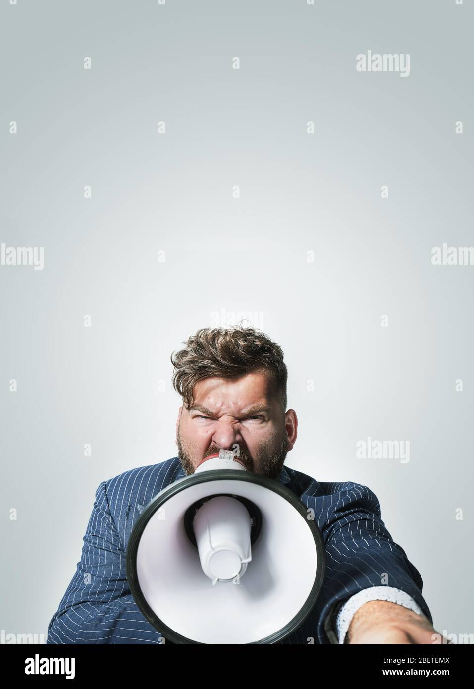 Plump boss yelling with a megaphone Stock Photo - Alamy