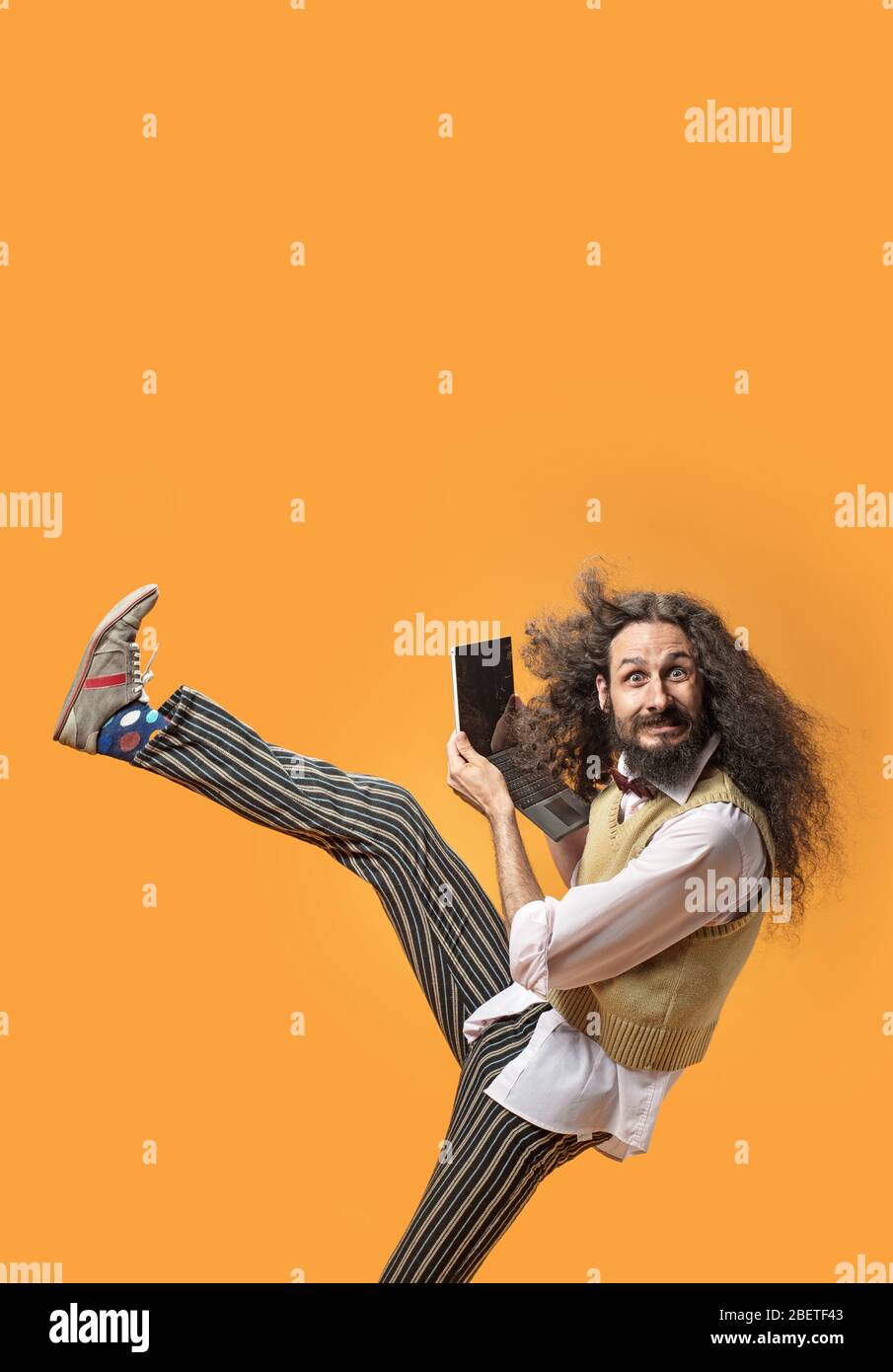 Skinny, odd nerd jumping with a notebook Stock Photo - Alamy