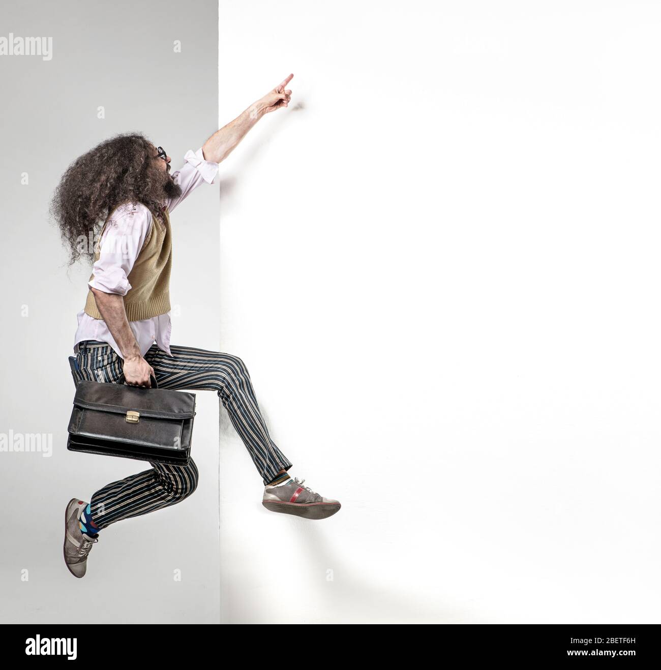 Eccentric man pointng on the white board Stock Photo - Alamy