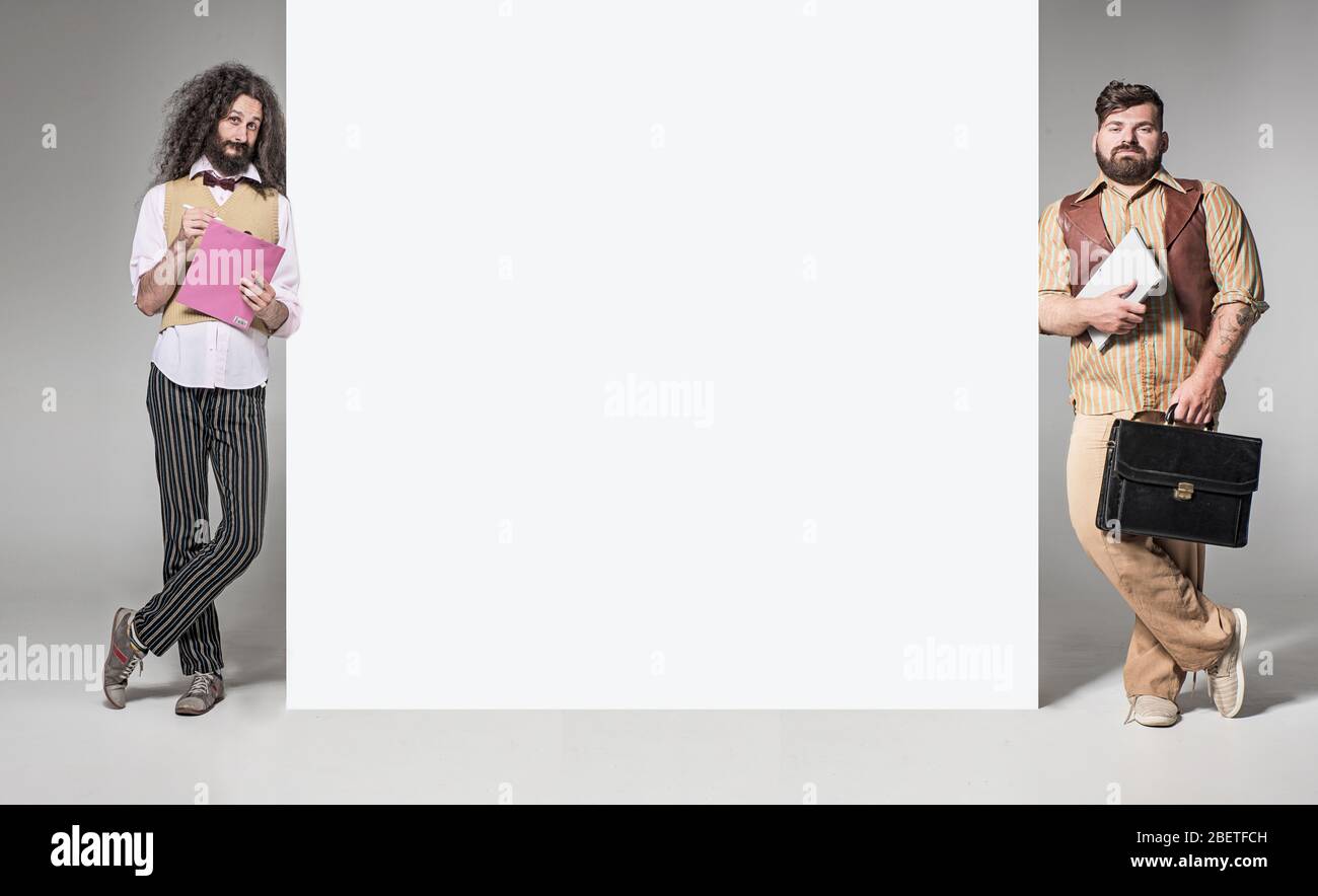 Portrait of two nerds posing next to the white board Stock Photo - Alamy