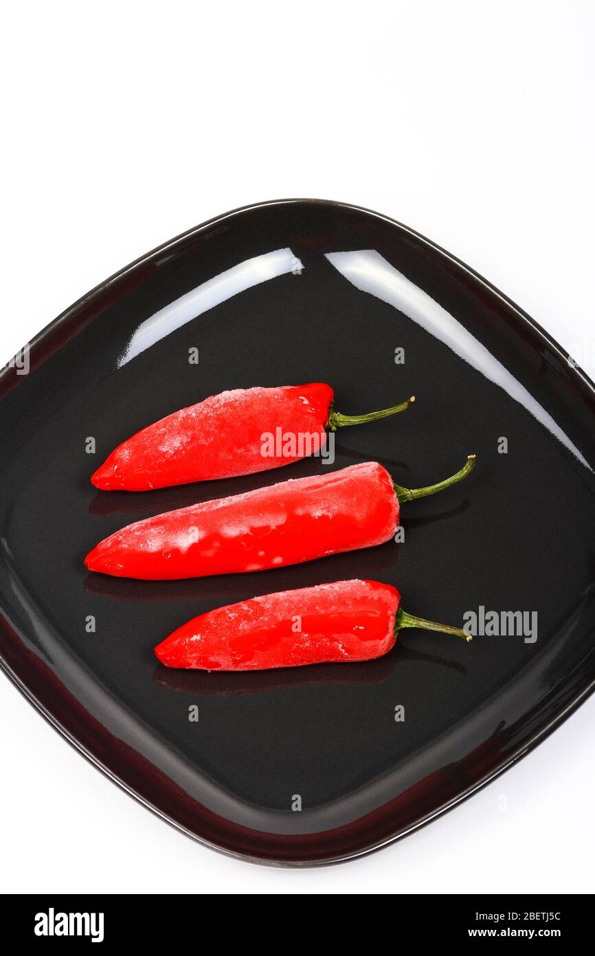 Red chilli peppers with ice crystals hot and cold concept Stock Photo ...
