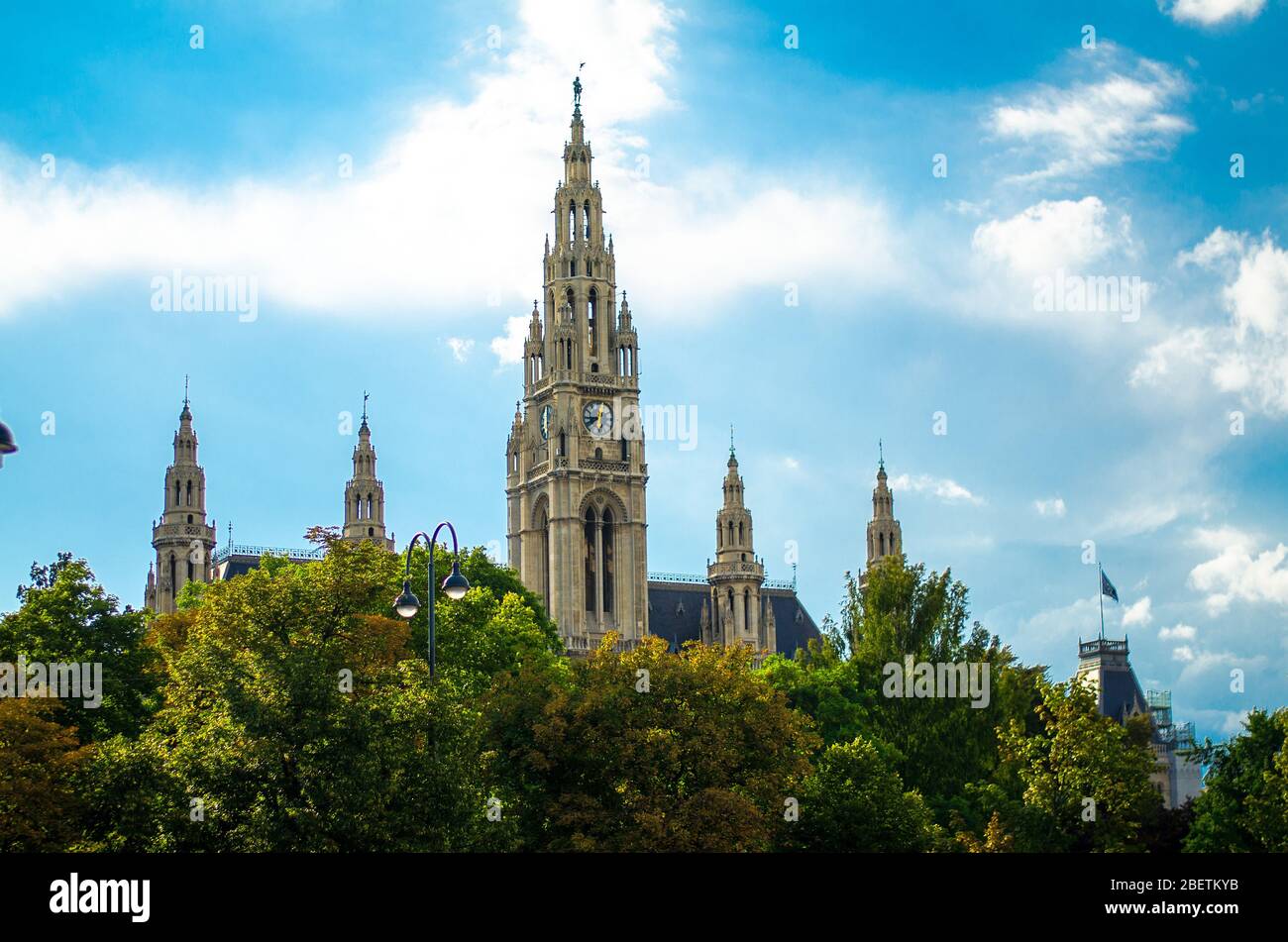 City Hall of Vienna (Rathaus) view through green trees in front of blue ...