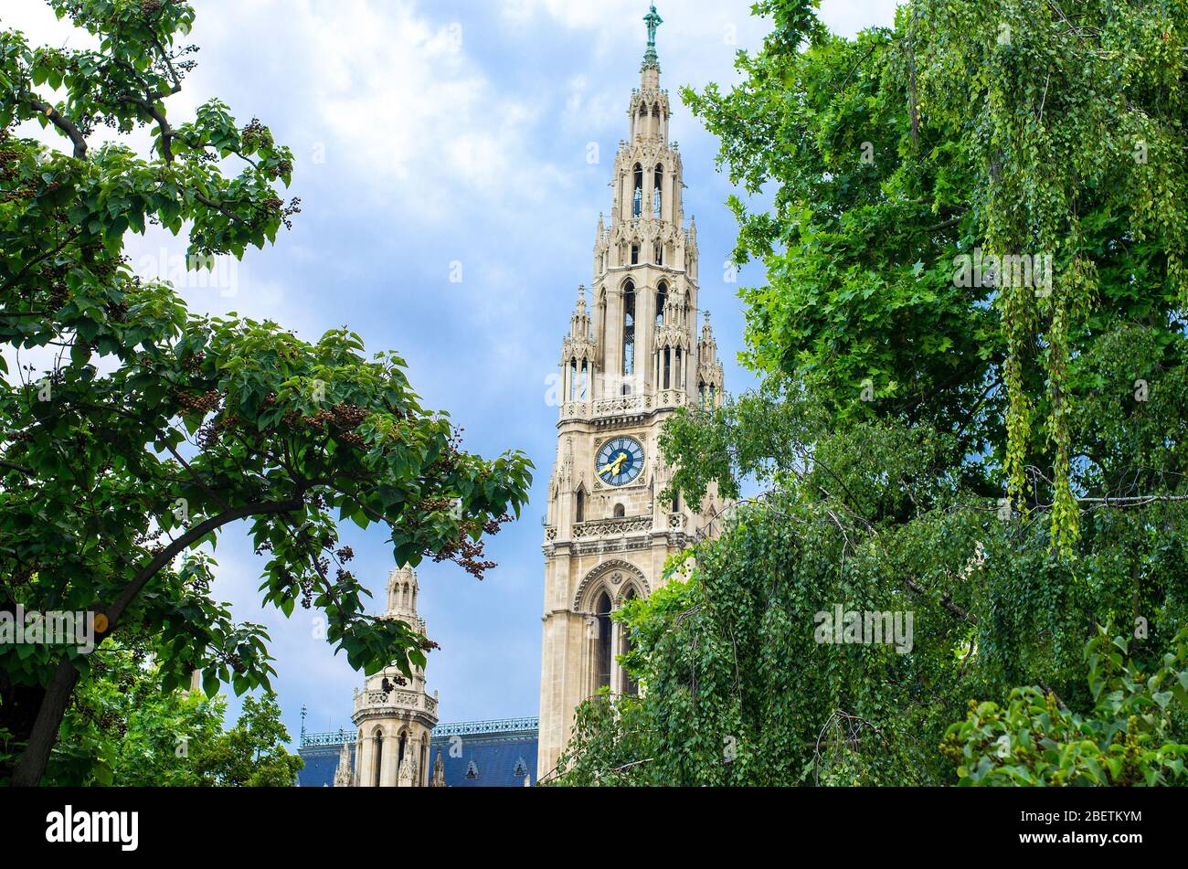 City Hall of Vienna (Rathaus) view through green trees in front of blue ...