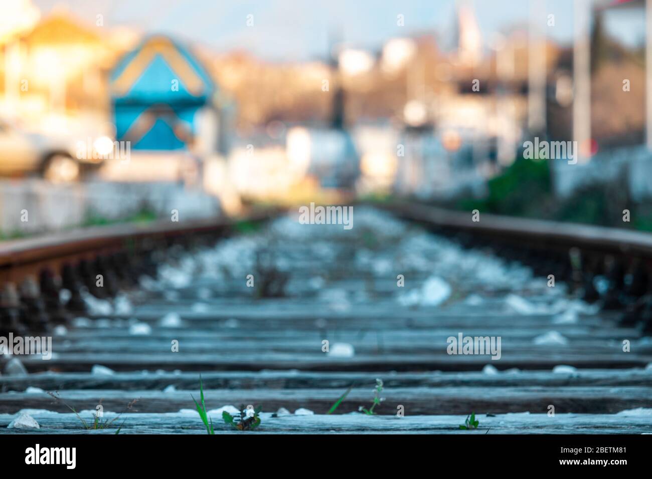 Closeup of old overgrown train tracks full of white pebbles. Blurred ...