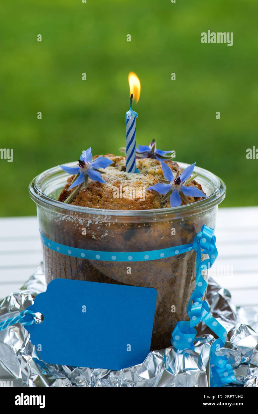 Cup cake in a glass with a candle Stock Photo - Alamy