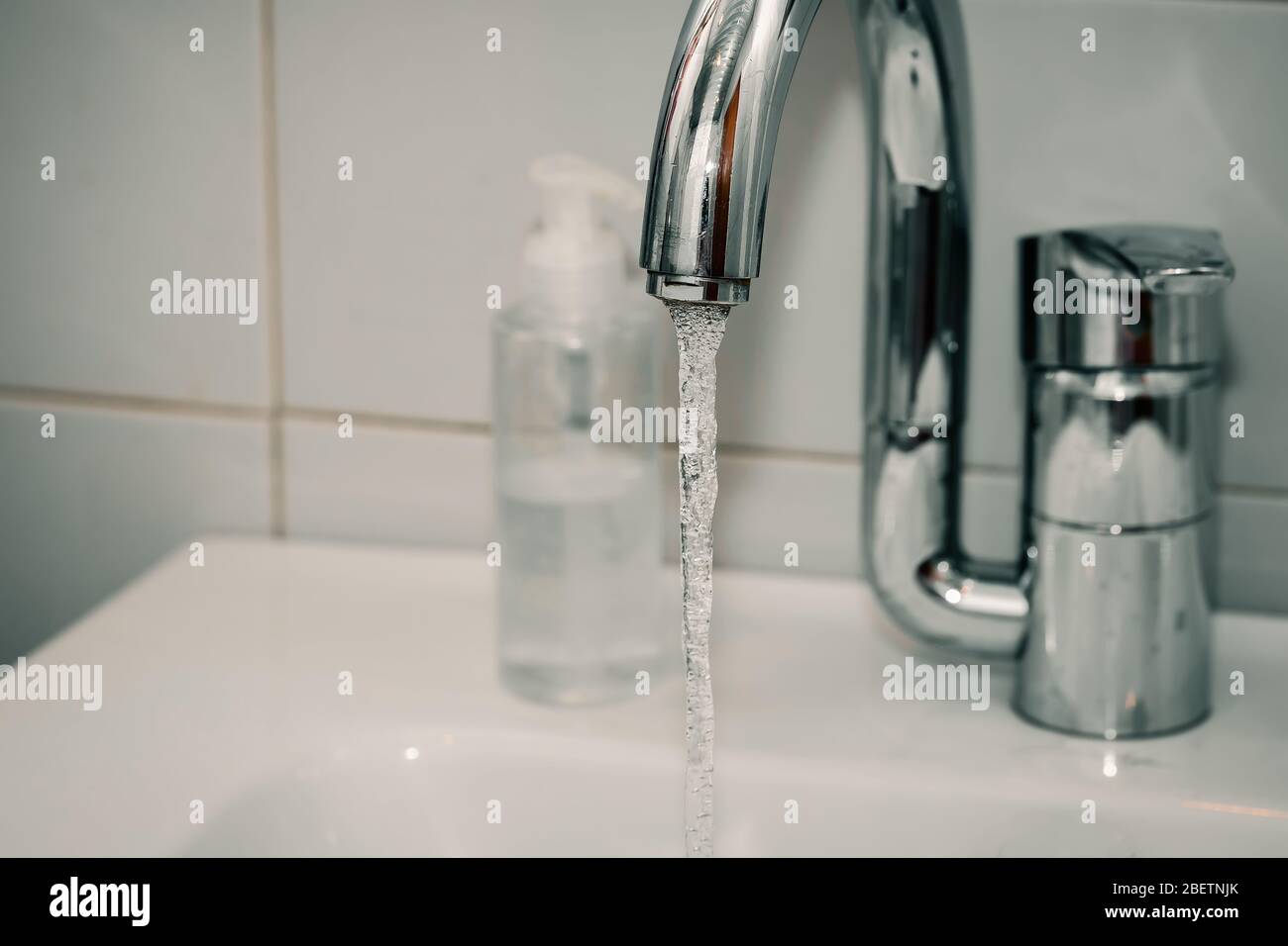 Modern hand wash basin. Solid tabletop surface and gray tile wall ...