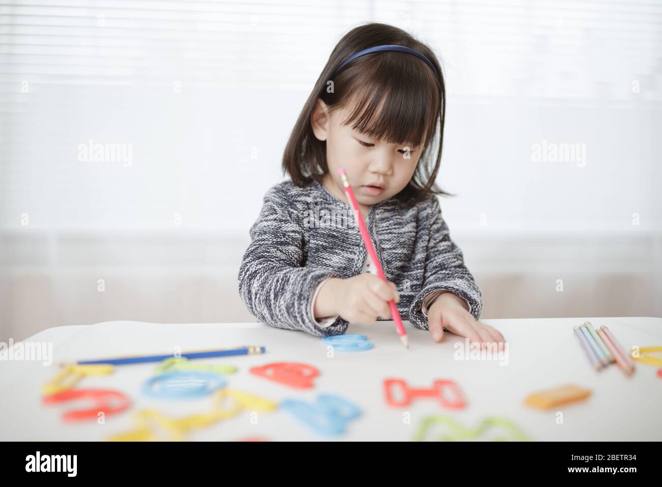 toddler girl practice writing letters for homeschooling Stock Photo - Alamy