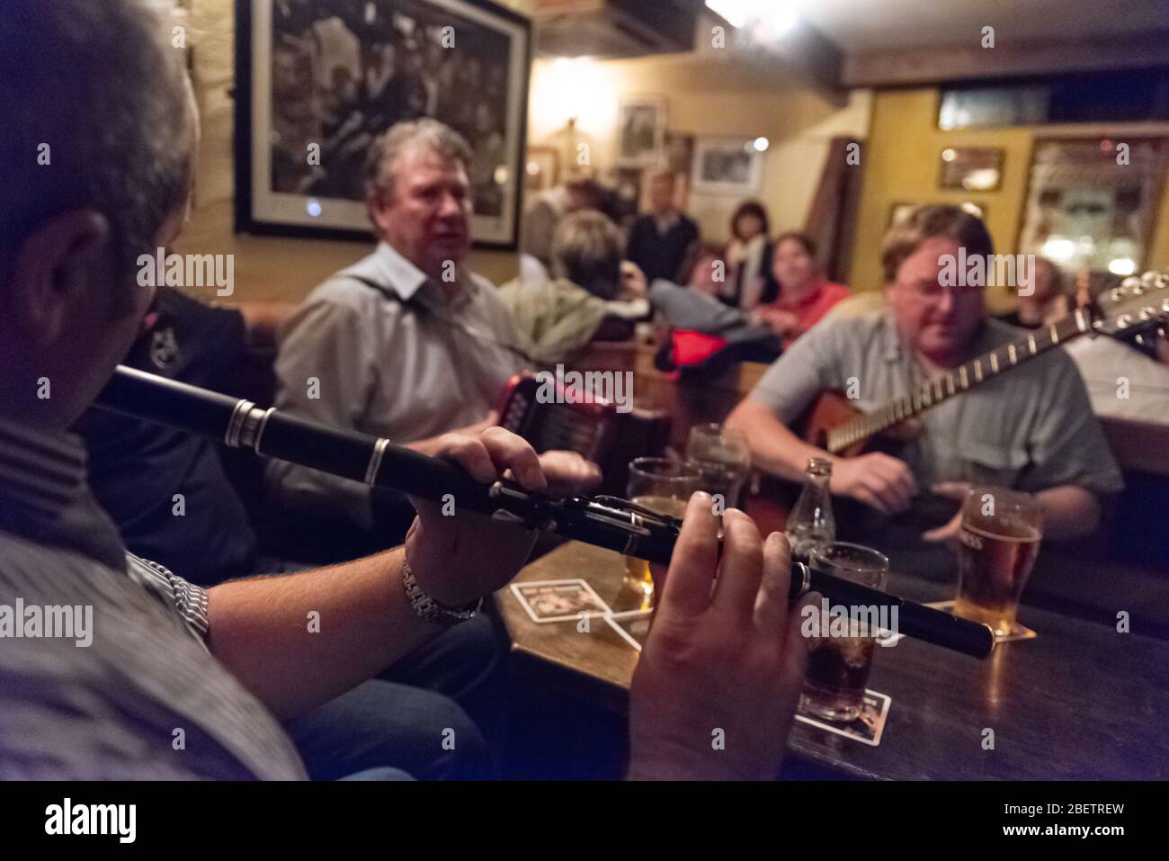 Three men playing music in an Irish pub in Doolin and other customers ...