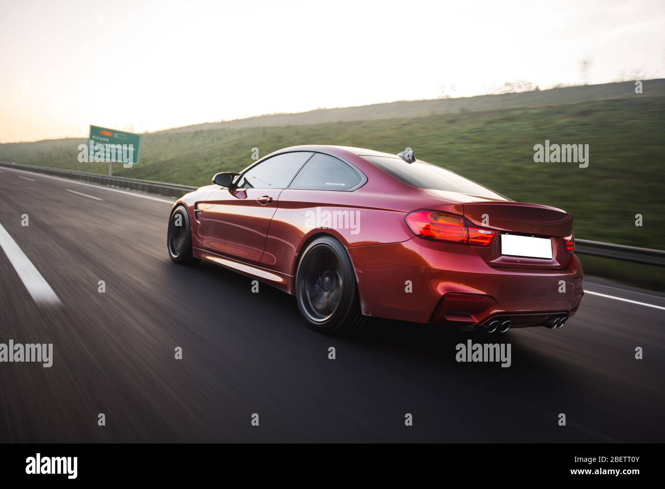 Red sedan cab driving across green hills Stock Photo - Alamy