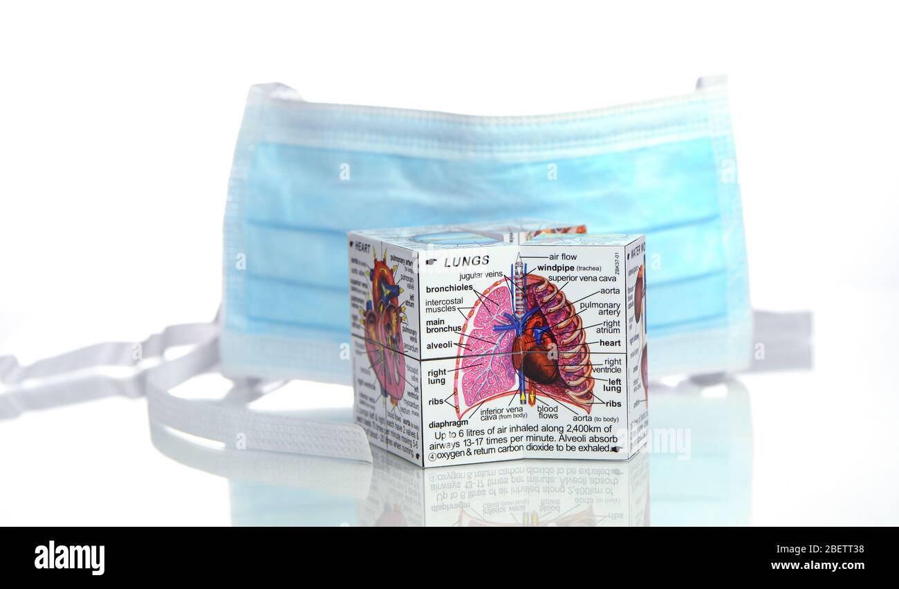 A surgical mask photographed alongside a cube medical diagram of the ...