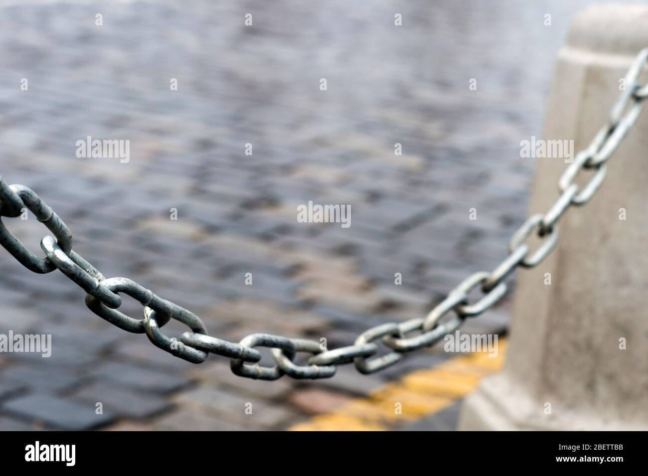 The metal chain is attached to the concrete support. The concept of ...