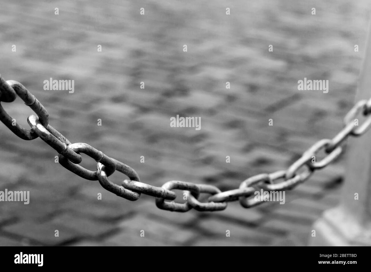 The metal chain is attached to the concrete support. The concept of ...