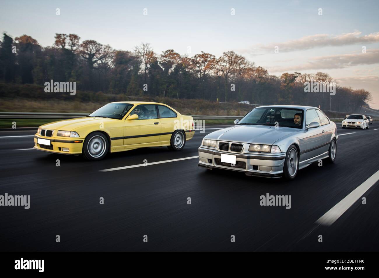 Yellow and silver cars passing each other on the highway Stock Photo ...