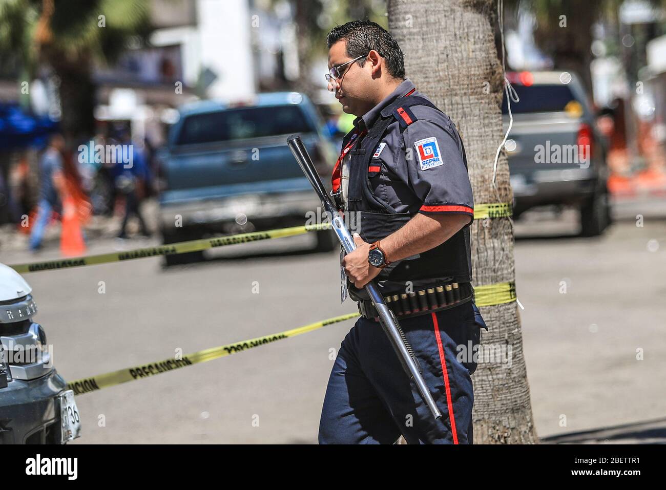 A guard from the Private Security company, SEPSA walks with his firearm ...