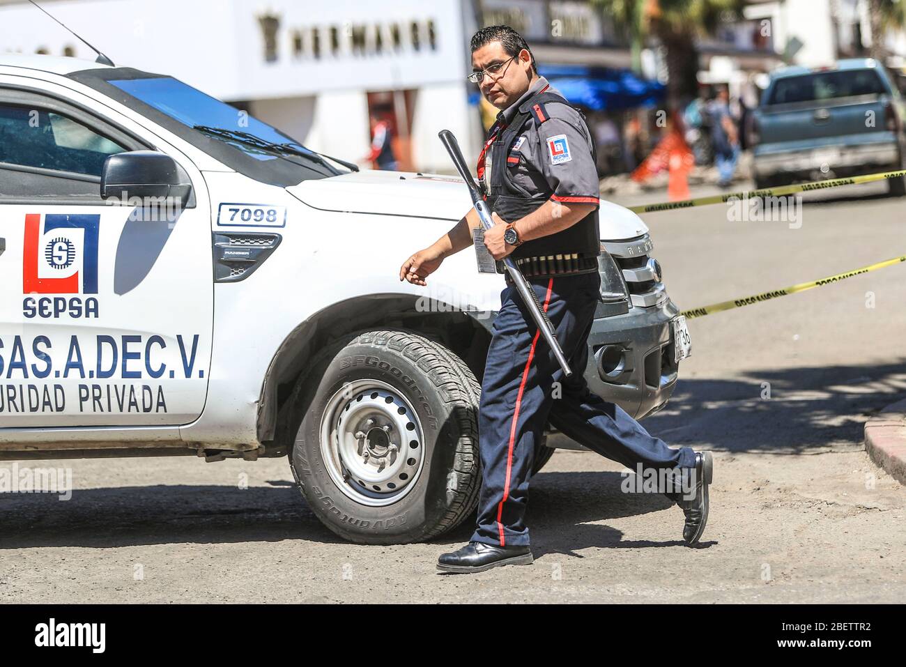 A guard from the Private Security company, SEPSA walks with his firearm ...