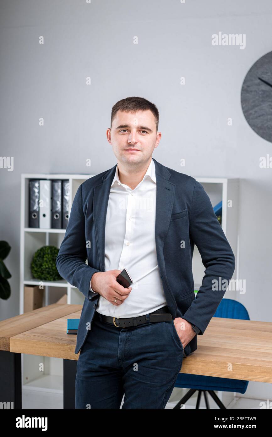 Portrait of a Caucasian male indoors posing in a jacket and white shirt ...