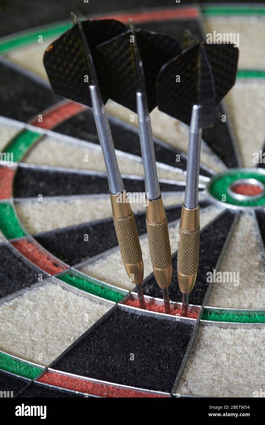 Three darts on triple ring target of dartboard, concept of victory and ...