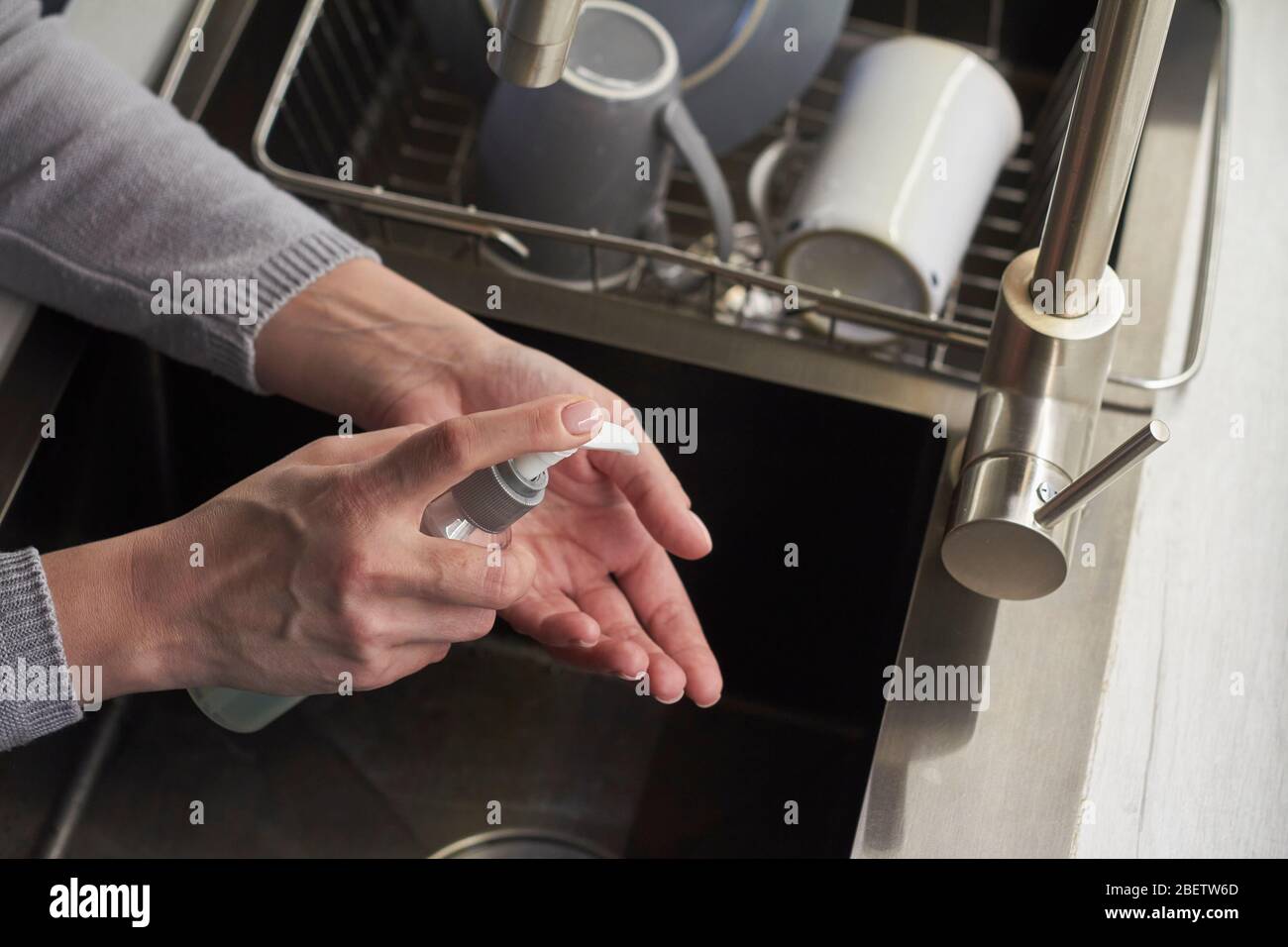 Hygiene concept, top view woman washes hands in the kitchen sink and ...