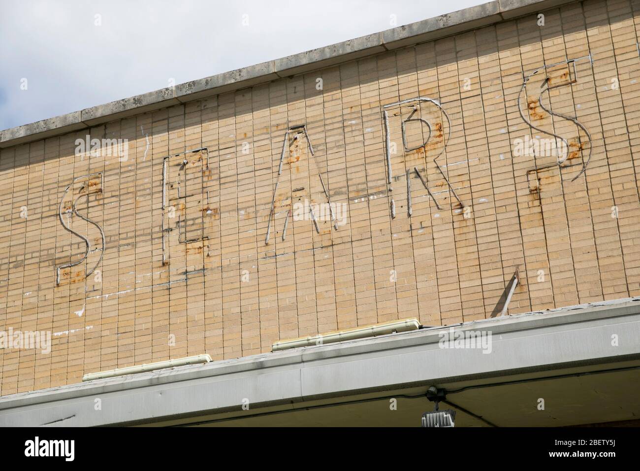 The faded outline of a logo sign outside of a closed and abandoned ...