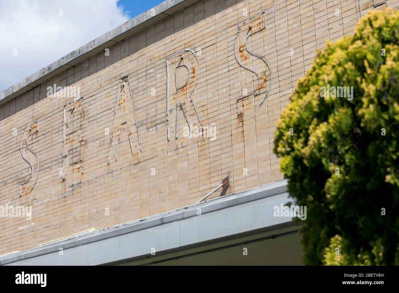 The faded outline of a logo sign outside of a closed and abandoned ...