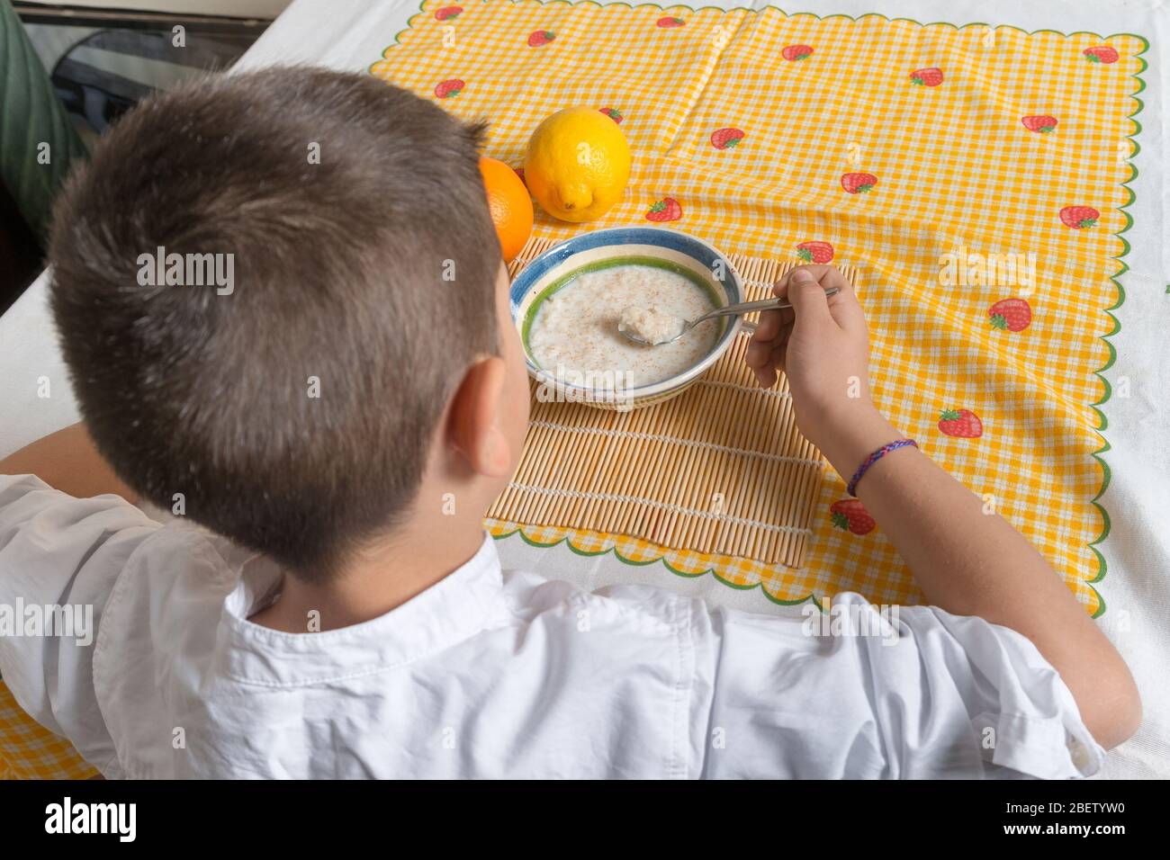 Rice pudding on the spoon a child is holding as he eats it Stock Photo ...