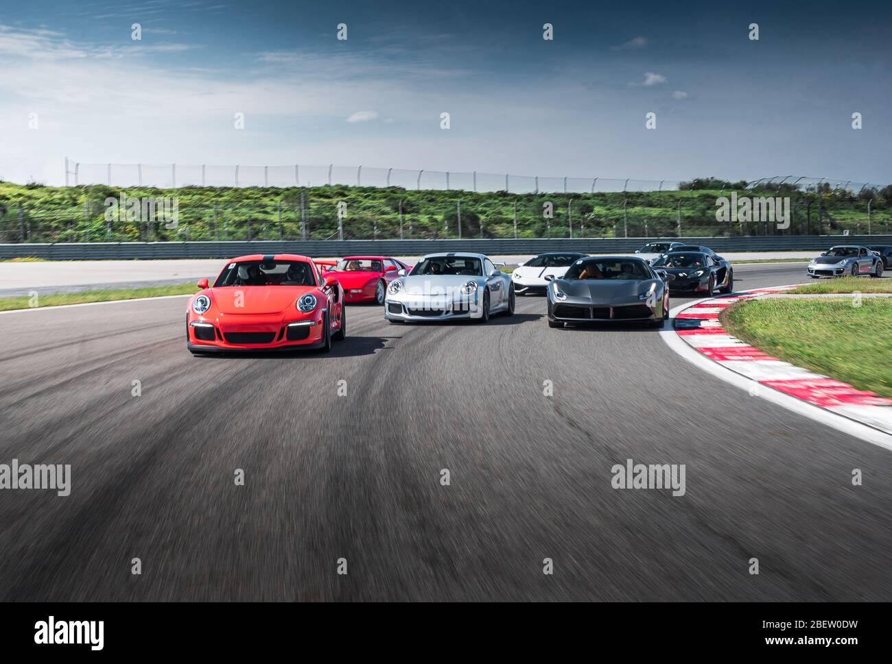Red sport car dominating other racing cars Stock Photo - Alamy