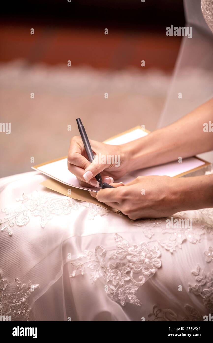 Wedding ceremony vows being written by a bride to be on a pad of paper ...