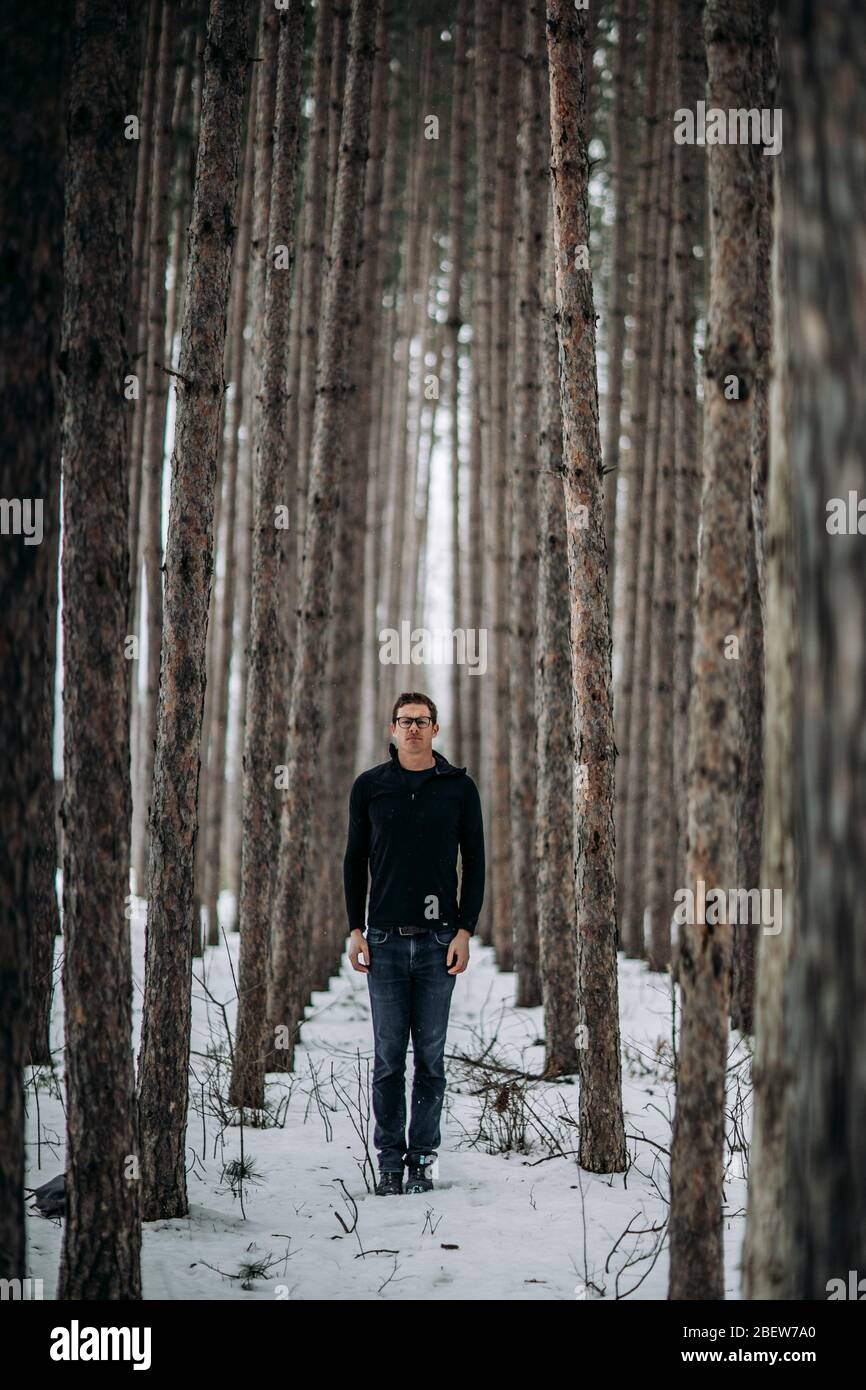 Young man walking alone among trees hi-res stock photography and images ...