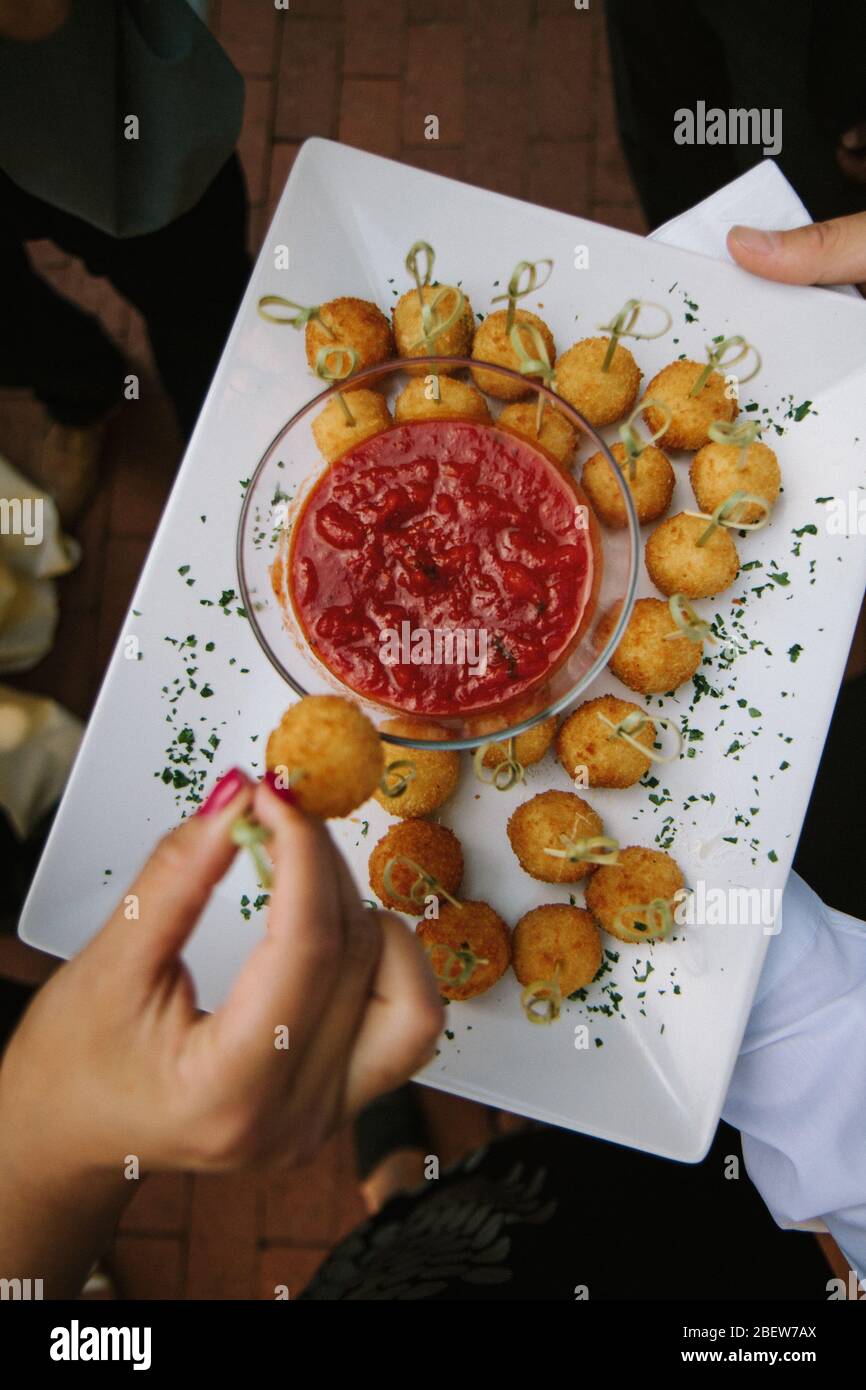 Appetizer plate from above with hand dipping food into sauce Stock ...