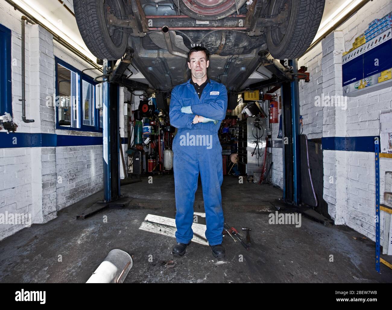 car mechanic standing under a car Stock Photo - Alamy