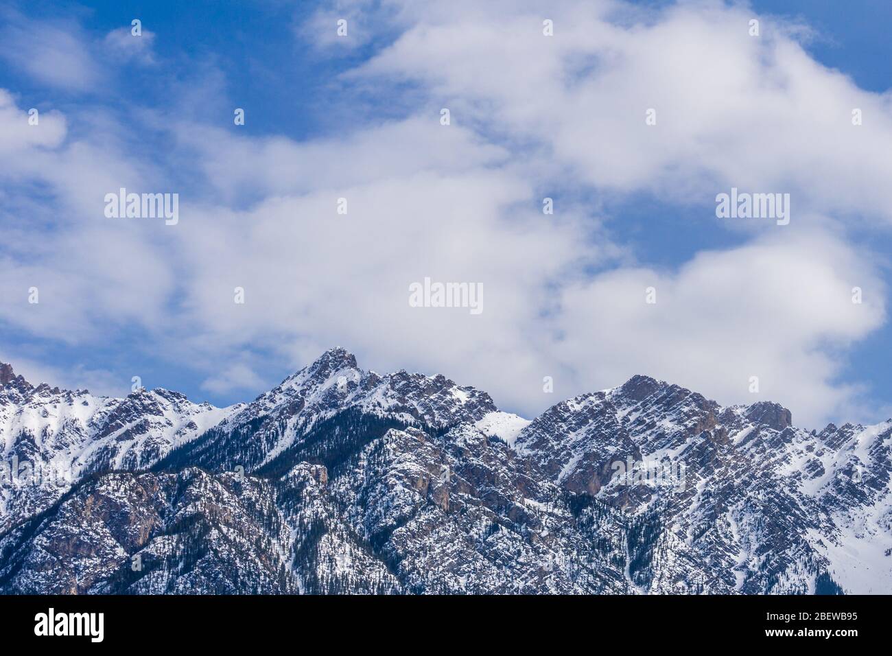 close-up view of the mountain peak with trees and snow on it sunny ...