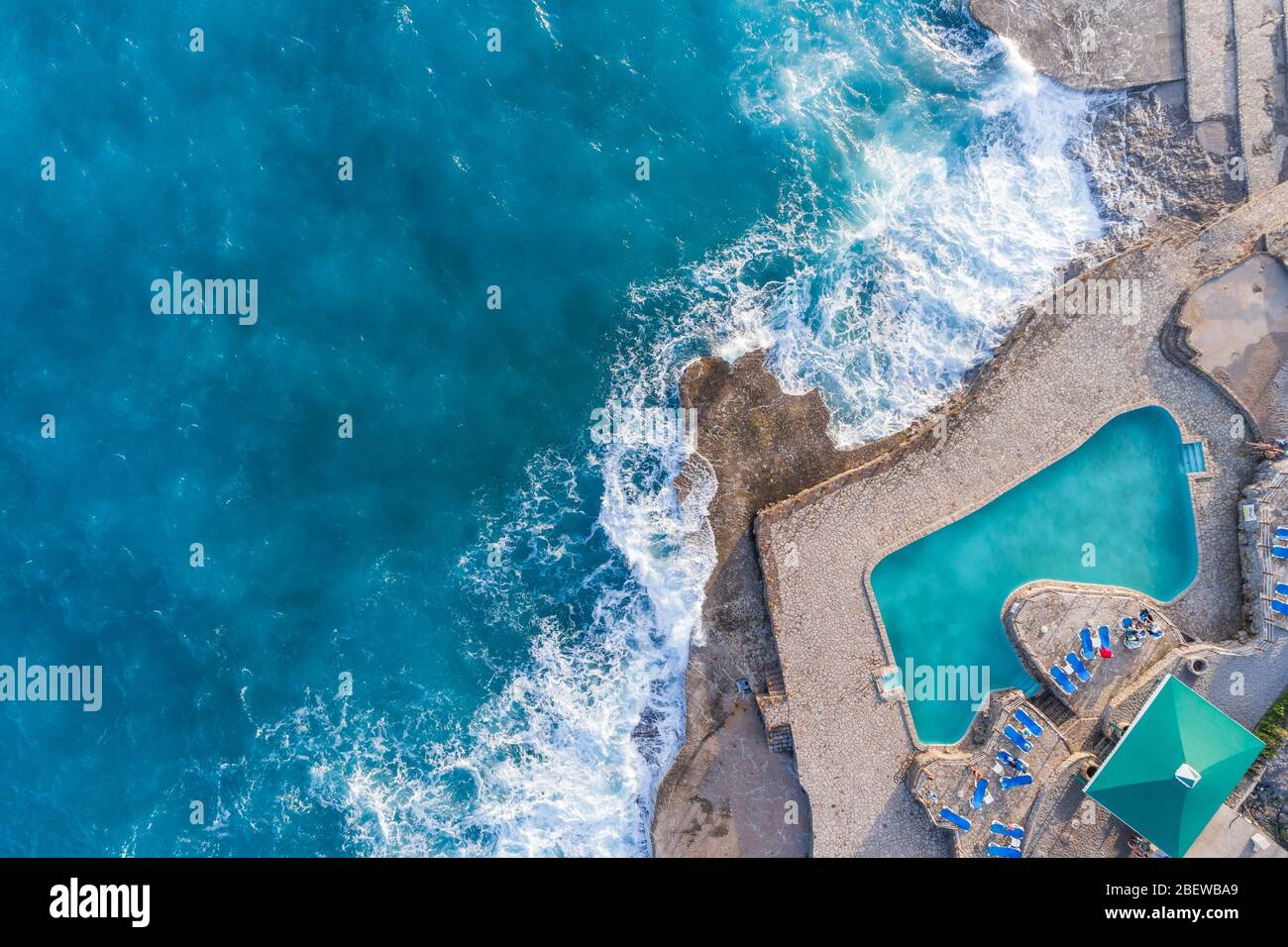 Aerial view of Ploce beach with swimming pool and stormy waves on the ...