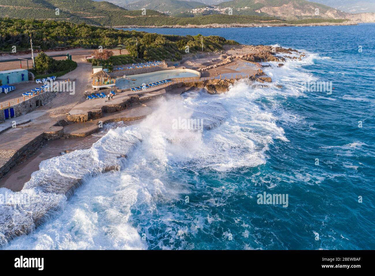 Aerial view of Ploce beach with swimming pool and stormy waves on the ...
