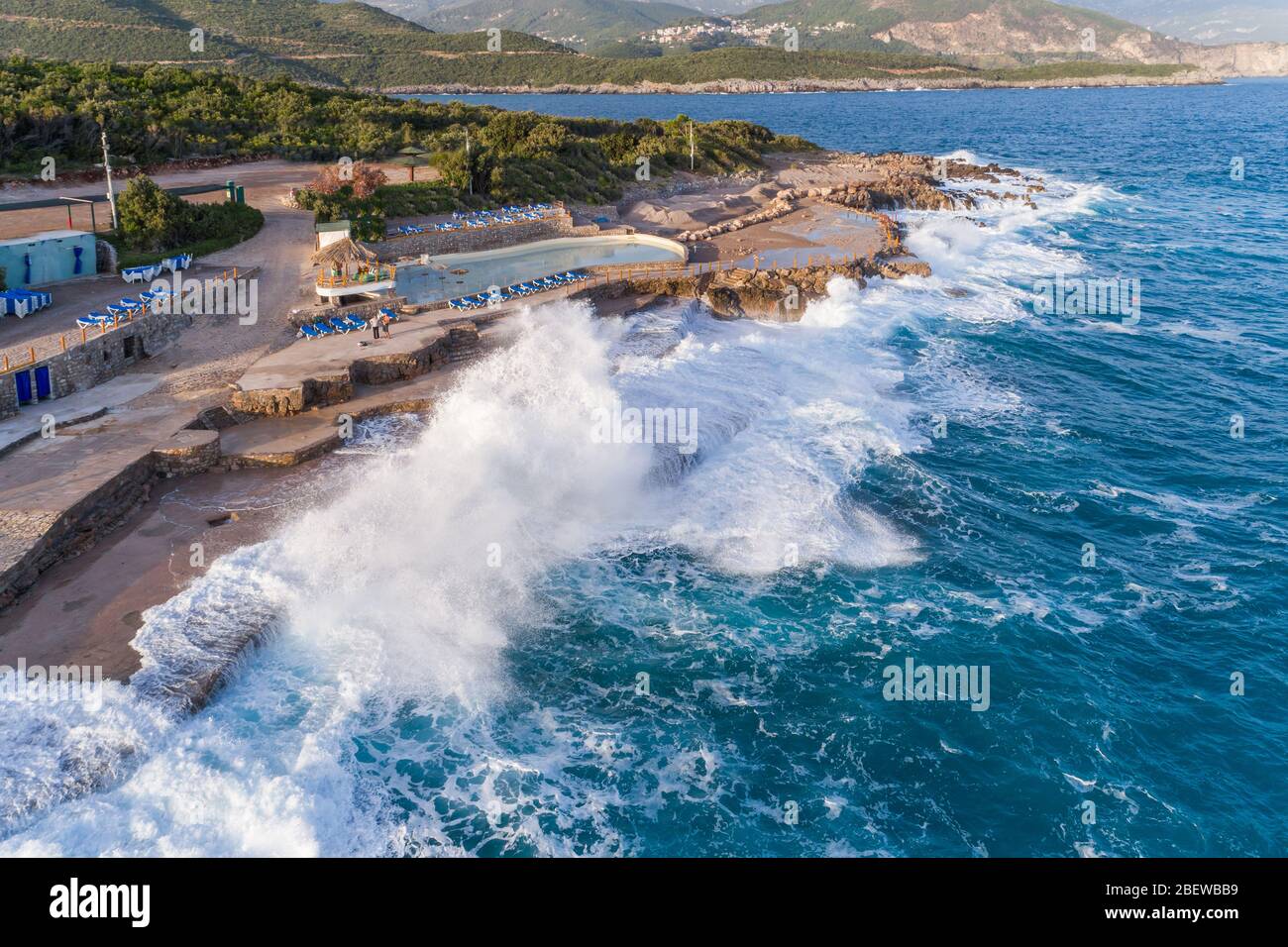 Aerial view of Ploce beach with swimming pool and stormy waves on the ...