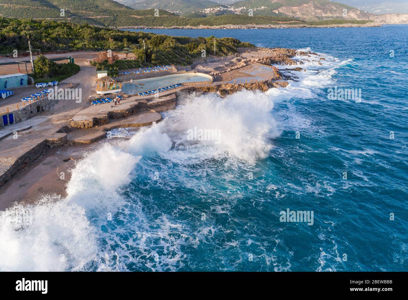 Aerial view of Ploce beach with swimming pool and stormy waves on the ...