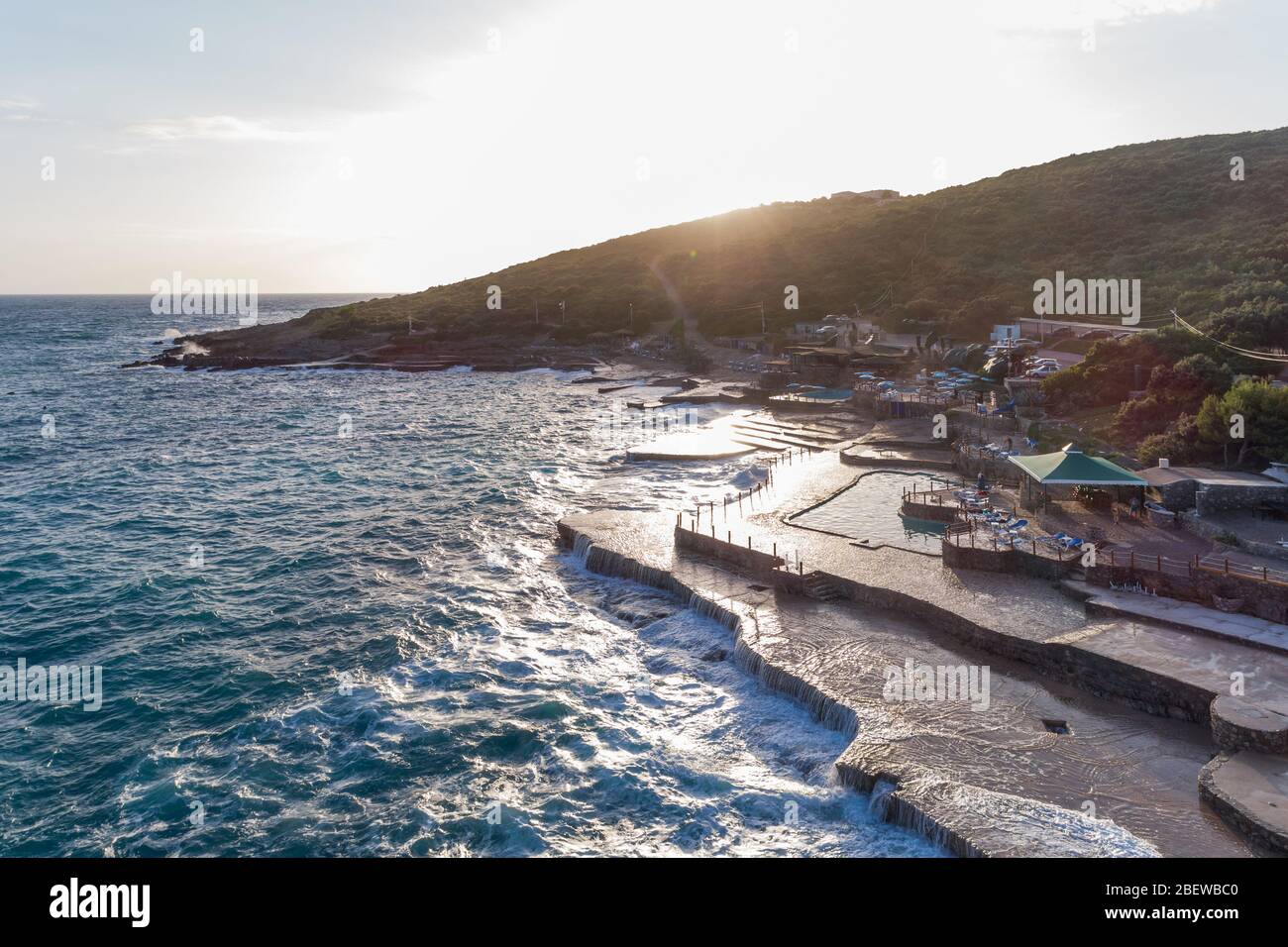 Aerial view of Ploce beach with swimming pool and stormy waves on the ...
