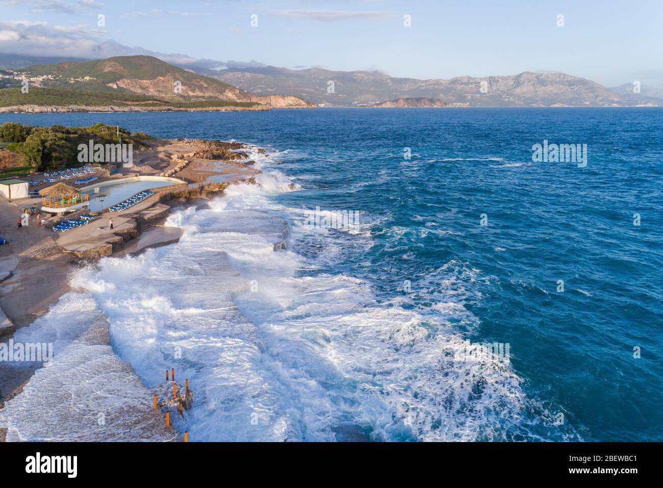 Aerial view of Ploce beach with swimming pool and stormy waves on the ...