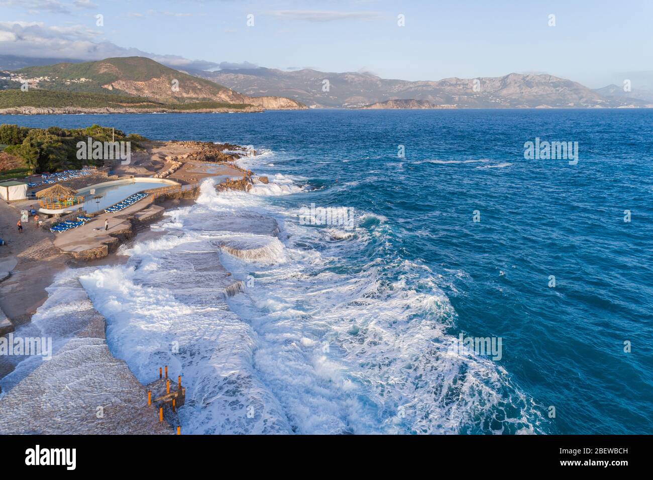 Aerial view of Ploce beach with swimming pool and stormy waves on the ...