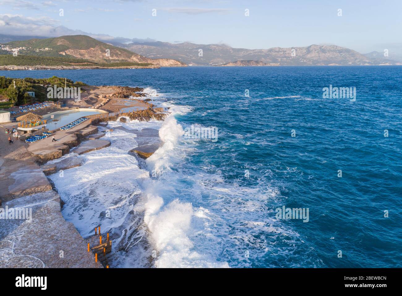 Aerial view of Ploce beach with swimming pool and stormy waves on the ...