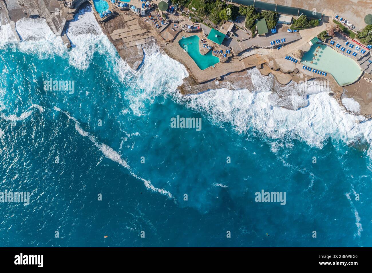 Aerial view of Ploce beach with swimming pool and stormy waves on the ...