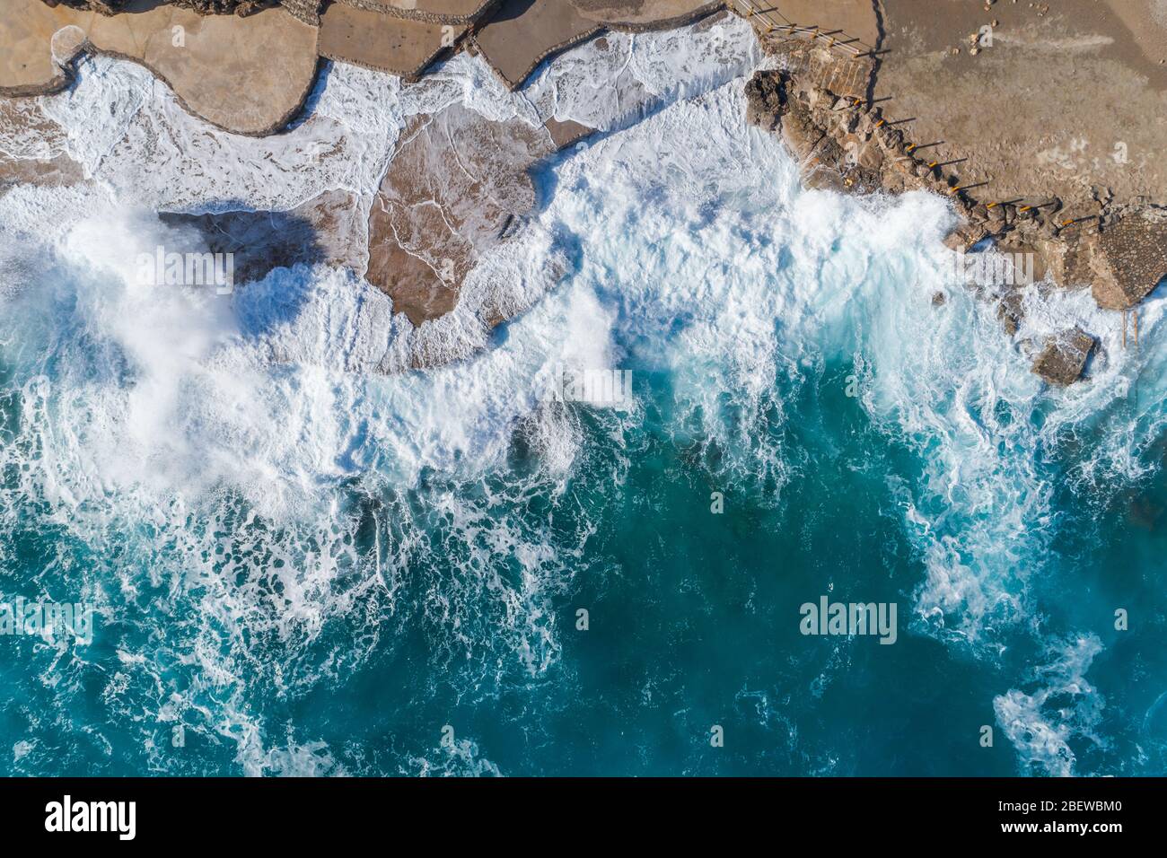 Aerial view of Ploce beach with swimming pool and stormy waves on the ...